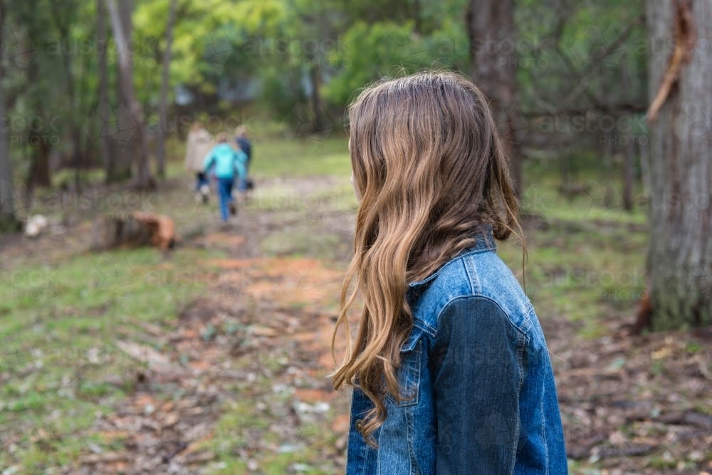 Image of teen girl lagging behind a group of kids in a forest ...