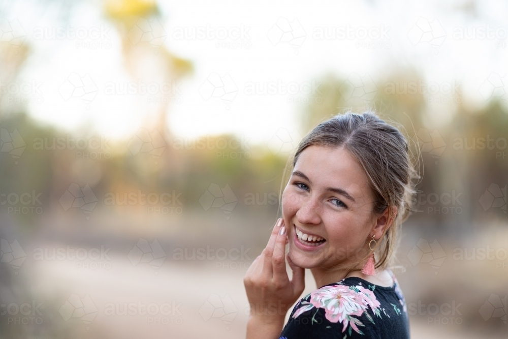 Image of teen girl looking over shoulder and laughing - Austockphoto