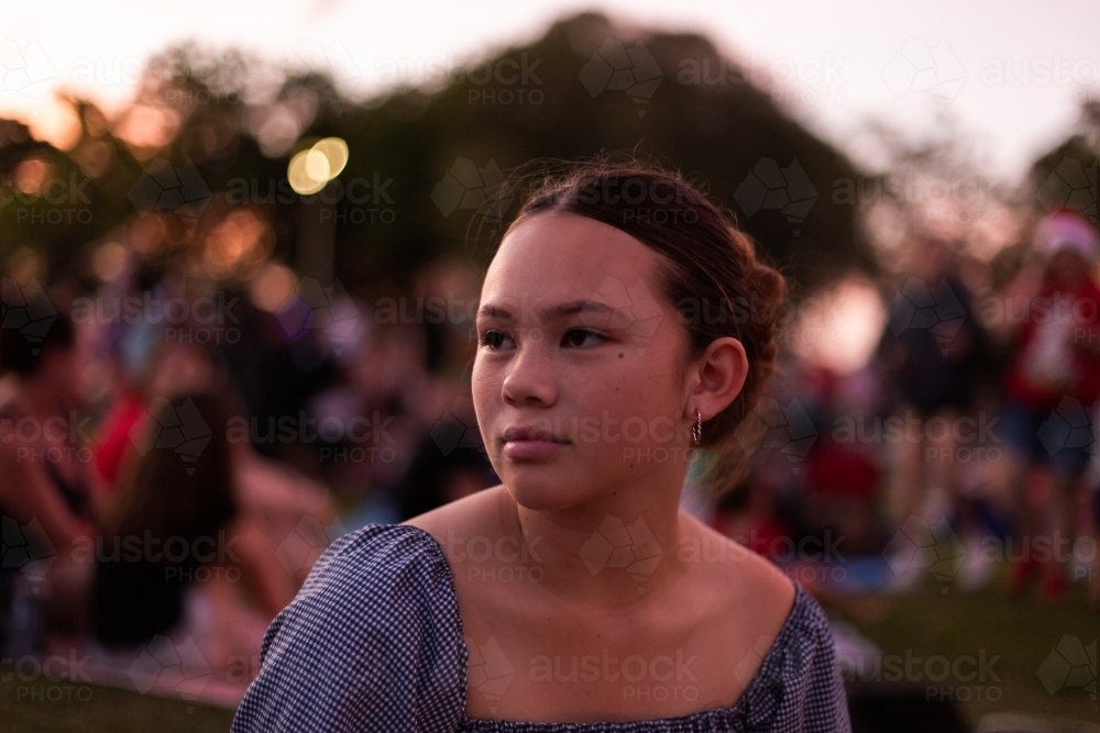 Image of teen girl out at dusk at a community event - Austockphoto