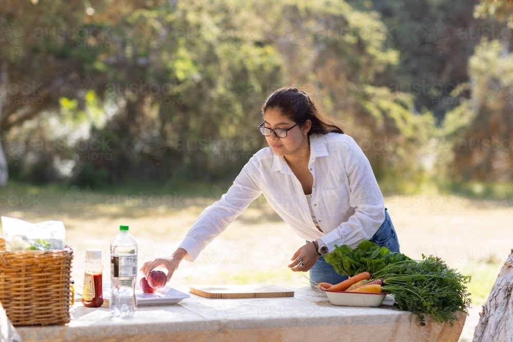 Image of teen girl placing peaches on a pate in preparation for an ...