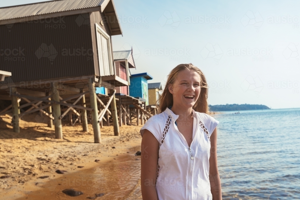Image of teen girl wearing rashie at the beach - Austockphoto