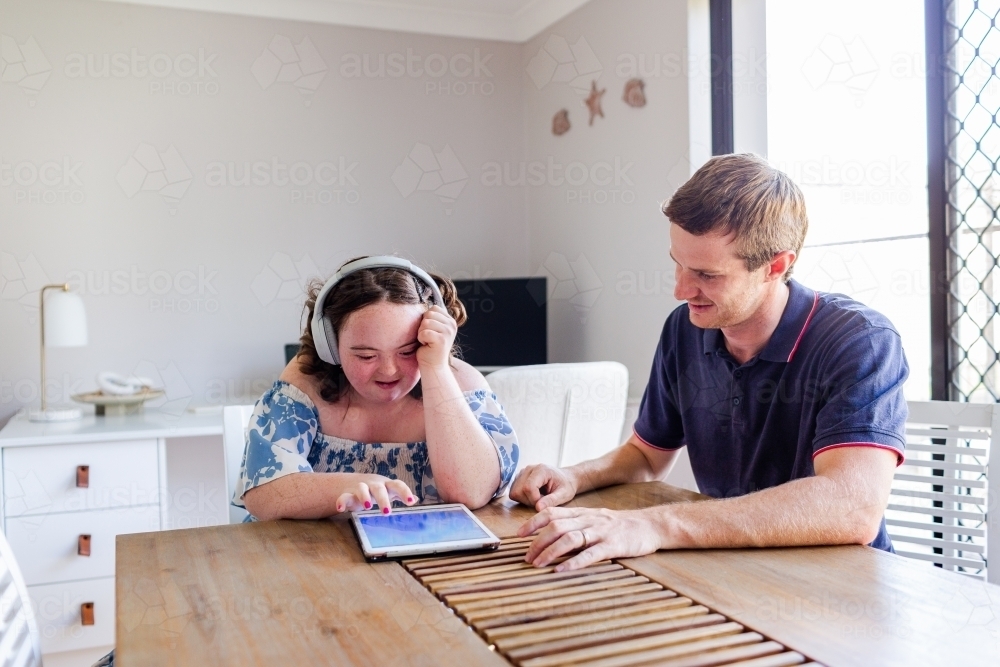 Image of Teen girl with down syndrome using tablet and wearing ...