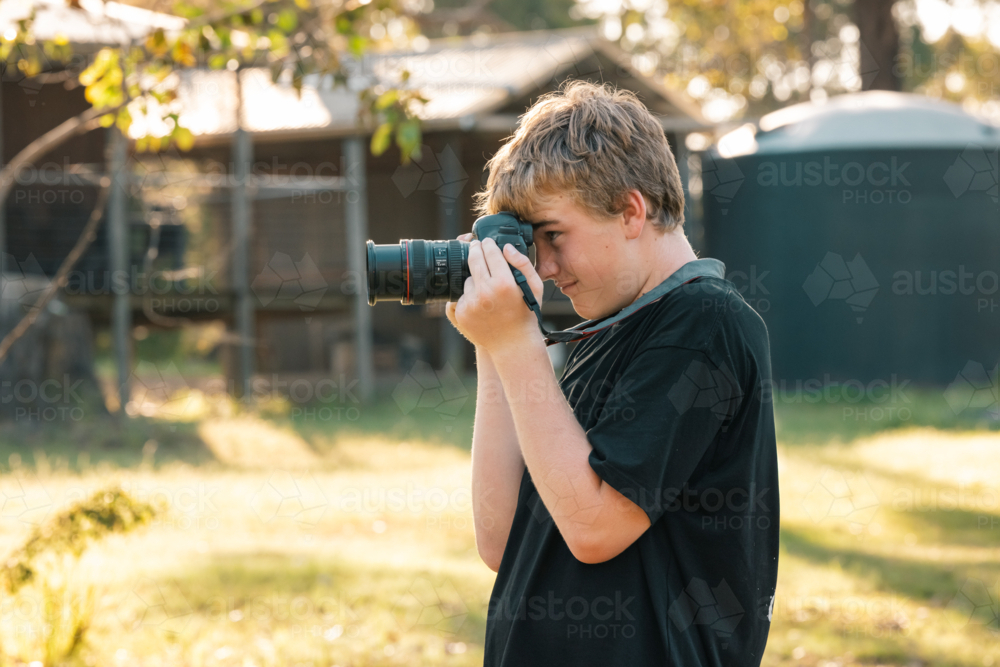 Image of Teenage boy using DSLR camera in the Australian bush ...