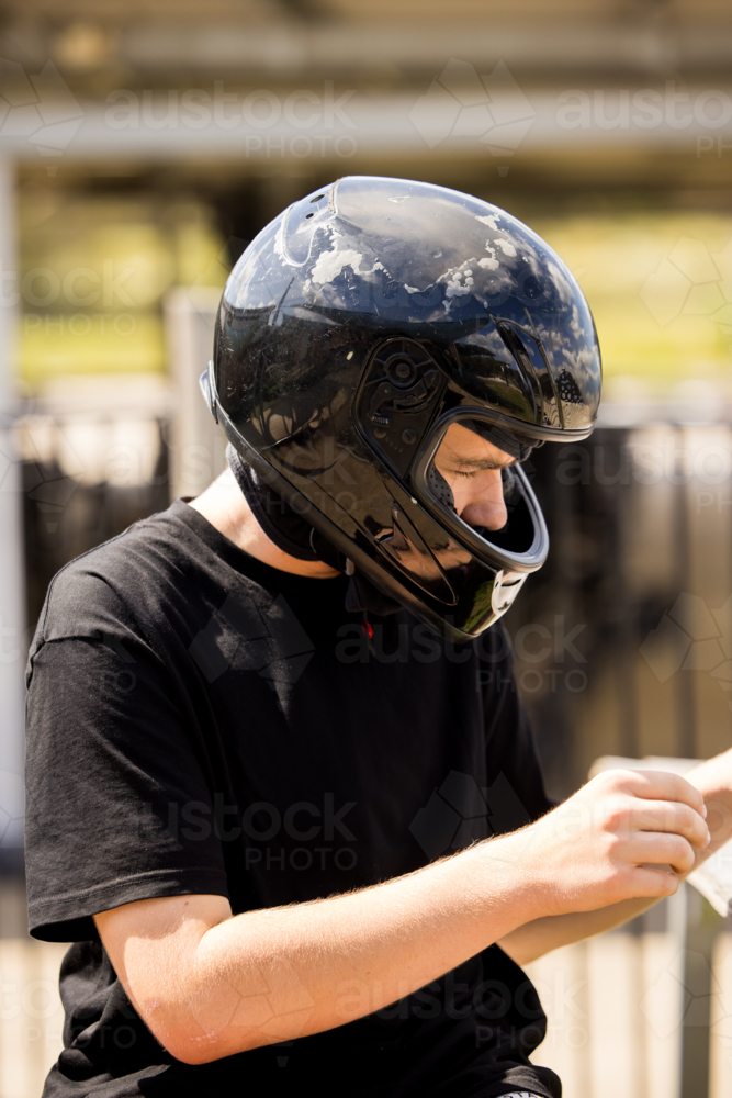 Image of Teenage boy wearing helmet ready for go-kart race - Austockphoto