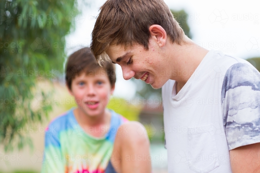 Image of Teenage boy with his little brother - Austockphoto