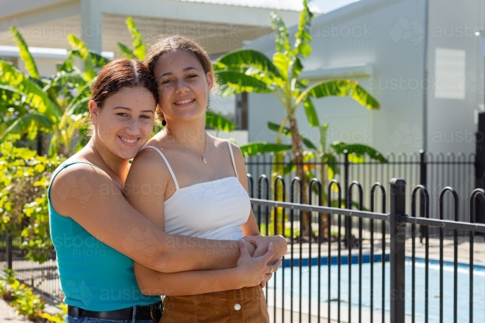 Image of teenage friends with arms around each other - Austockphoto