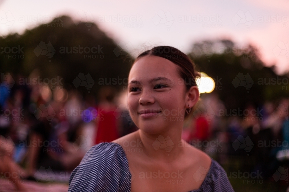 Image of teenage girl at a gig at sunset - Austockphoto