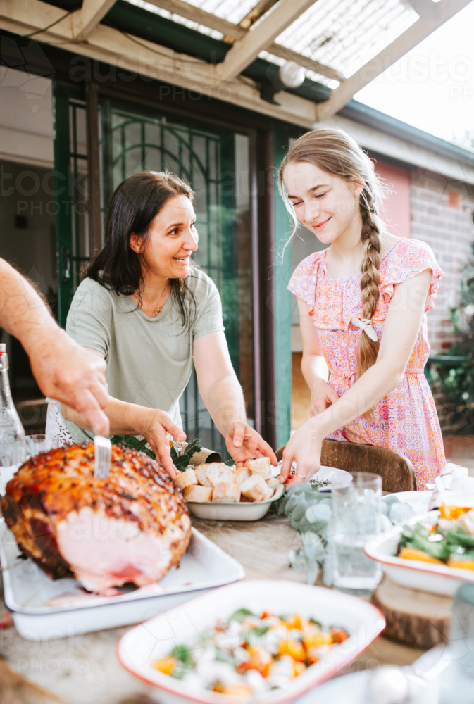 Image of Teenage girl helping mum setup the table for christmas dinner ...