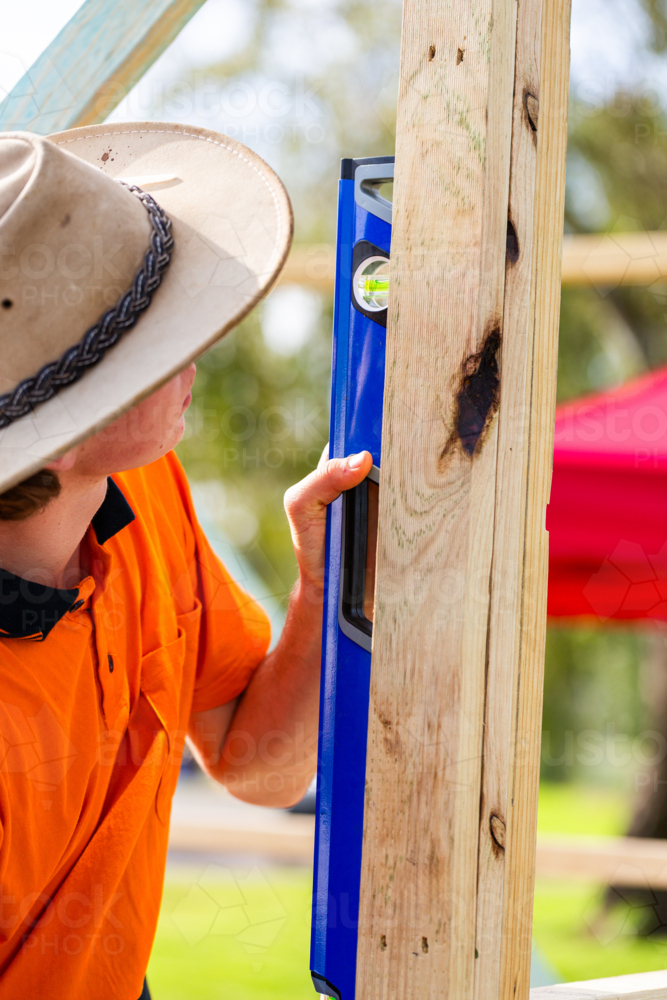 Image of Teenaged Australian tradie apprentice using level tool on ...