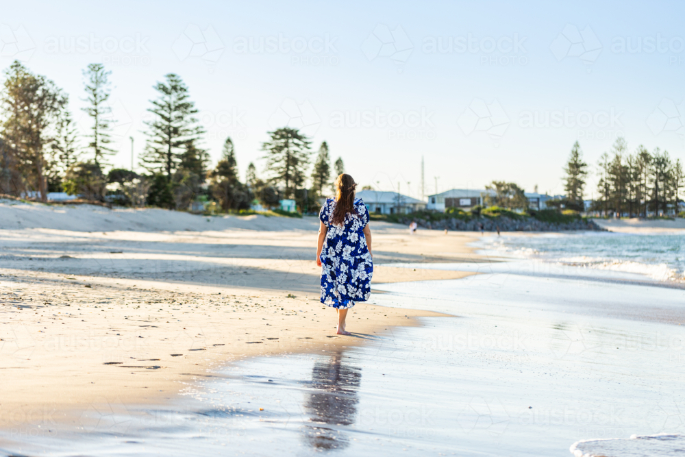 Image of Teenaged Torres Strait Islander girl walking along coastal shoreline in traditional ...