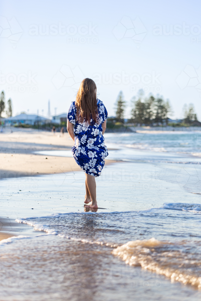 Image of Teenaged Torres Strait Islander girl walking along coastal shoreline in traditional ...