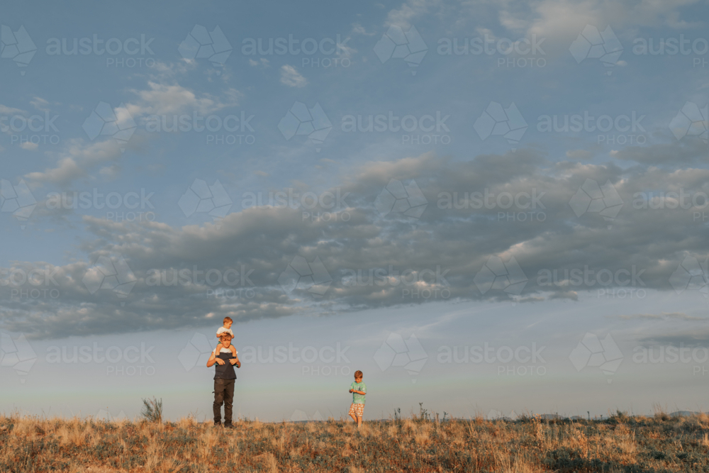 Image of Teenager giving happy little boy a shoulder ride with a blue ...