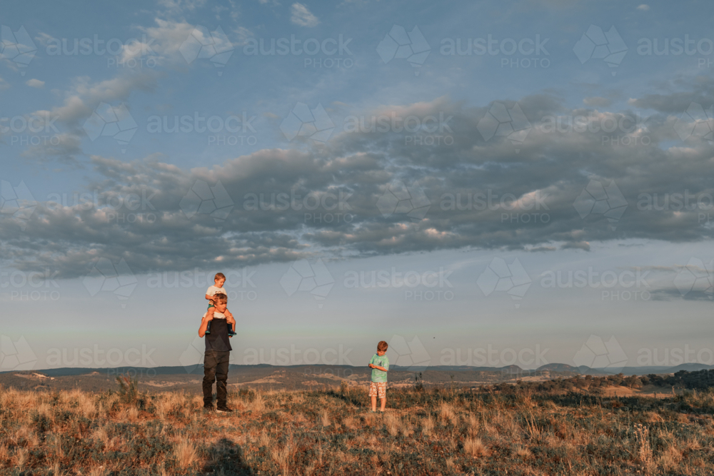 Image of Teenager giving happy little boy a shoulder ride with a blue ...