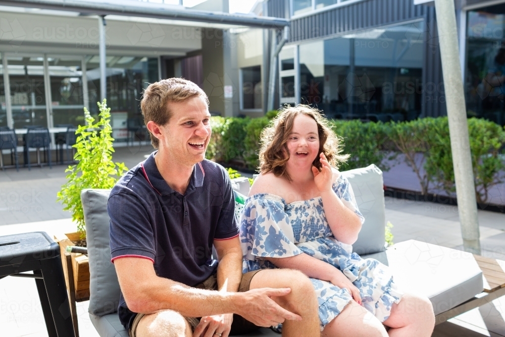 Image of Teenager talking with young adult disability worker outside at ...