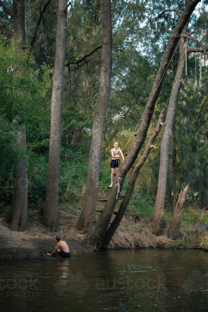 Image of Teenagers climbing tree with rope swing at the river ...