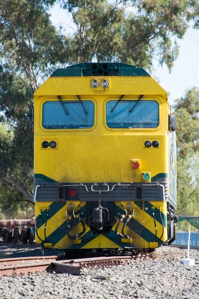 Image of The face of a yellow train coming towards the camera ...