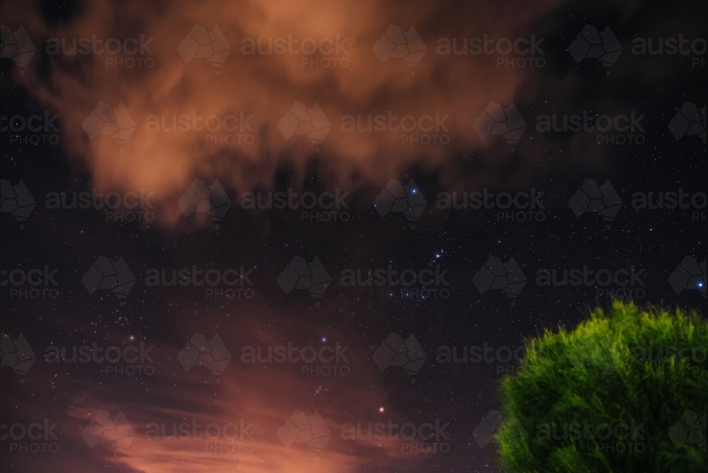 Image of The sky at night with peach clouds - Austockphoto