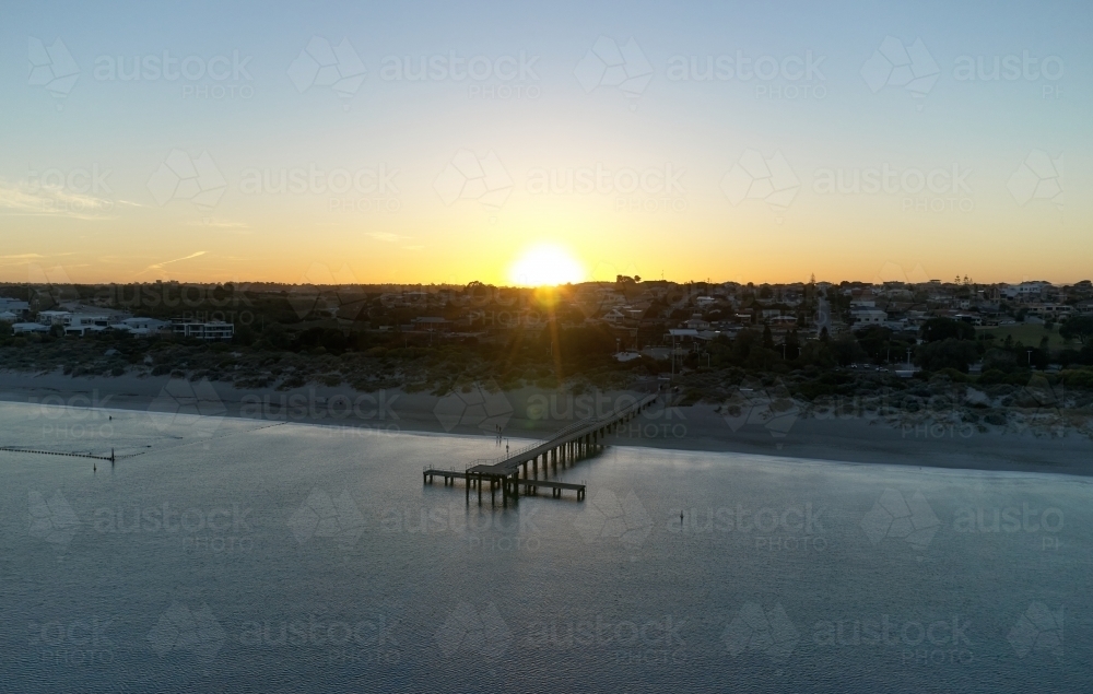 Image of The sun rising over the horizon, with a view across the water ...