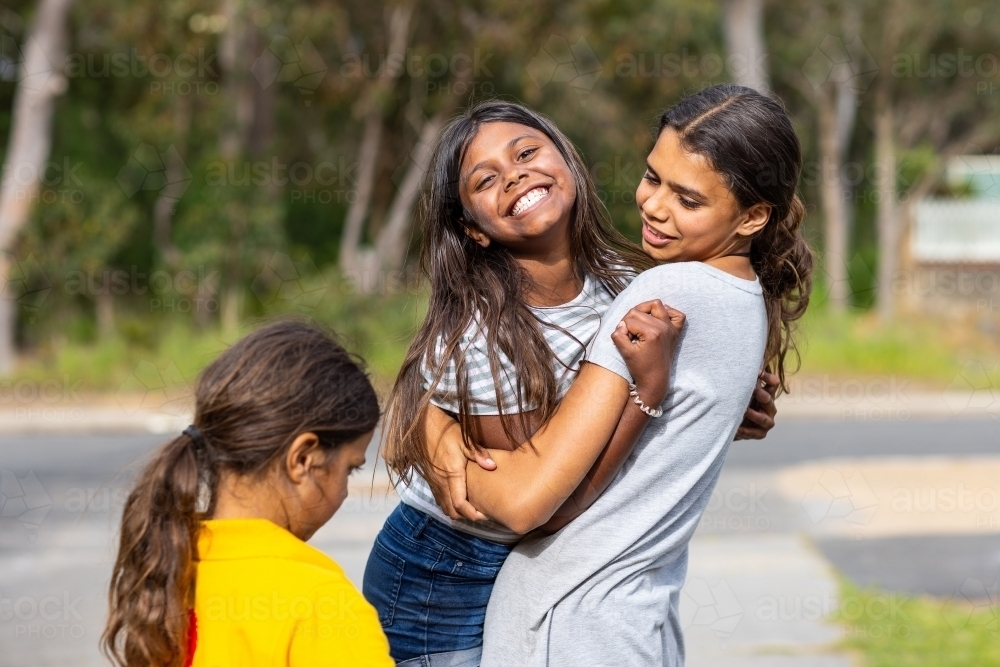 Image of three aboriginal girls outside their home in a country town ...