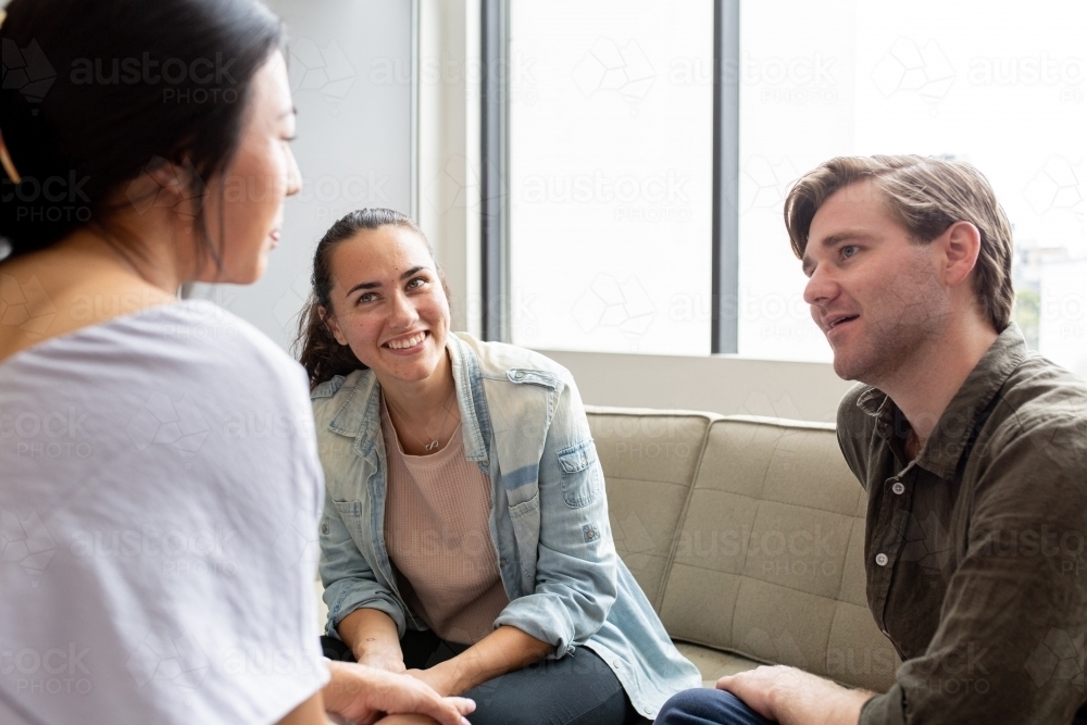 Image of Three designers meeting in an office chatting and smiling ...