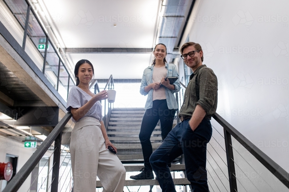 Image of Three designers standing on office stairs in an industrial ...