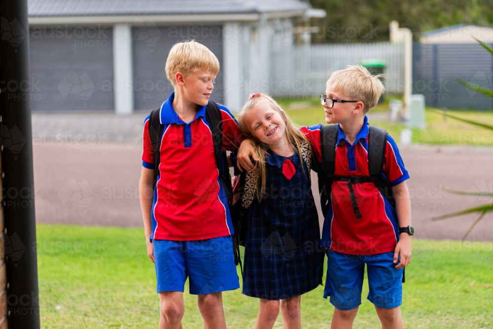 Image of Three happy primary aged kids with backpacks standing together ...