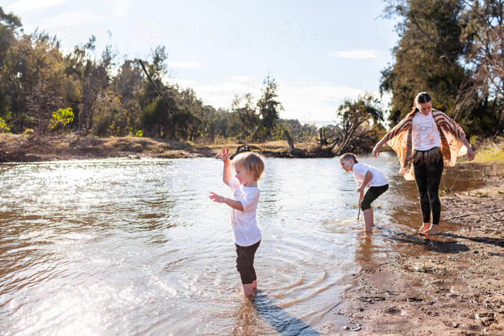 Image of Three happy siblings playing in sparkling morning light ...