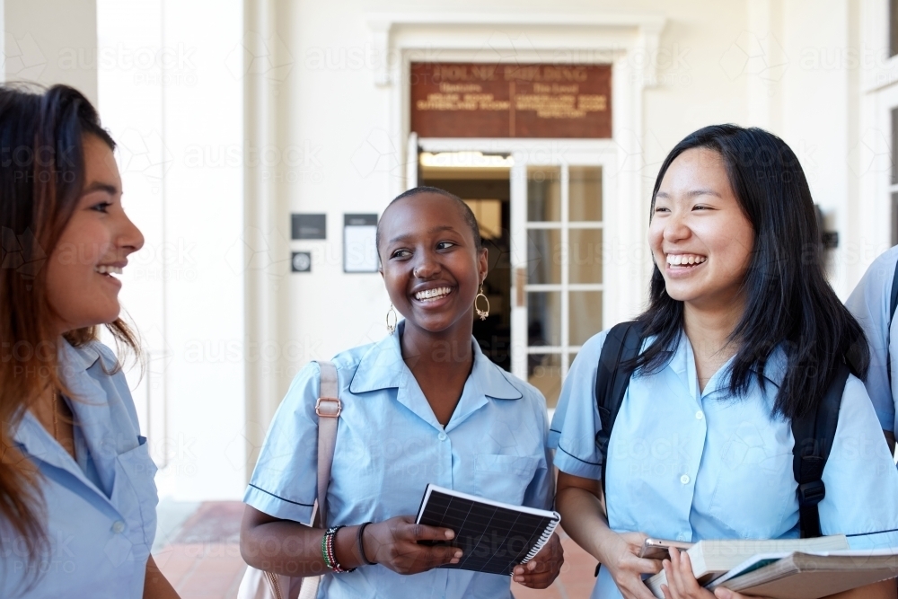 Image of Three High School friends laughing whilst checking their ...