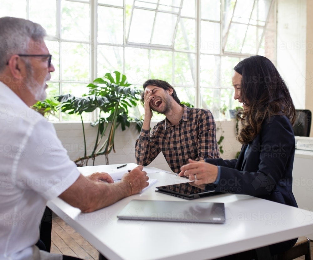 Image of Three people sitting, collaborating in an office - Austockphoto