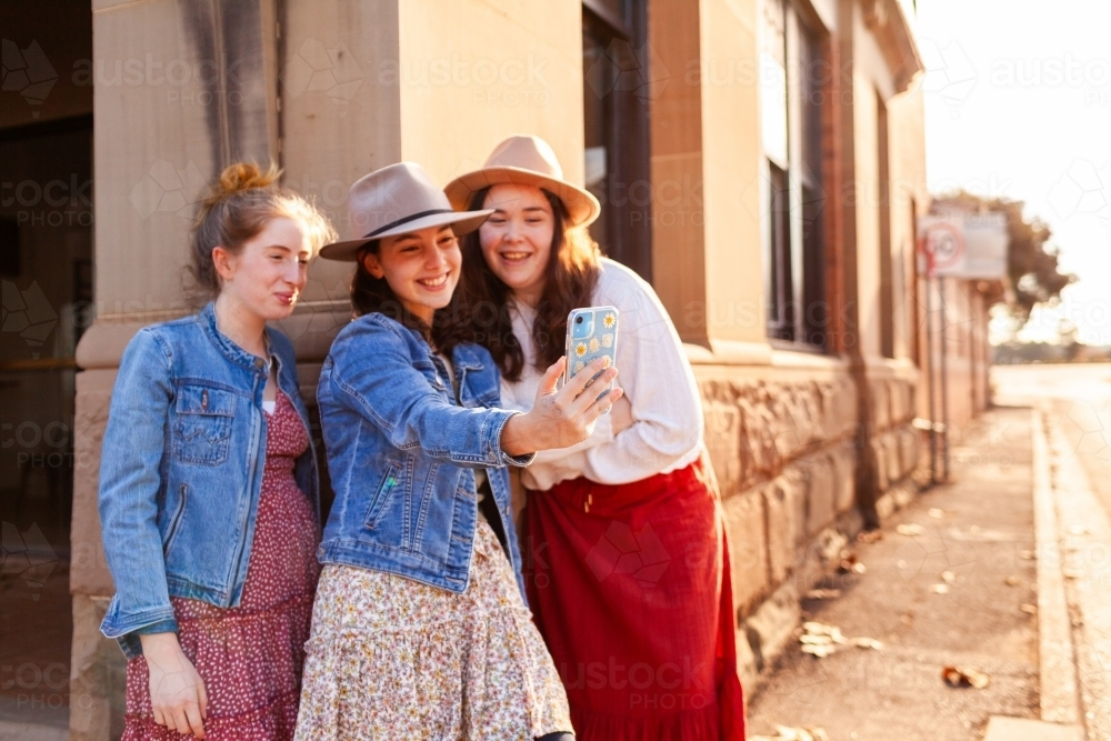 Image of Three teen friends taking a selfie photo together in golden ...