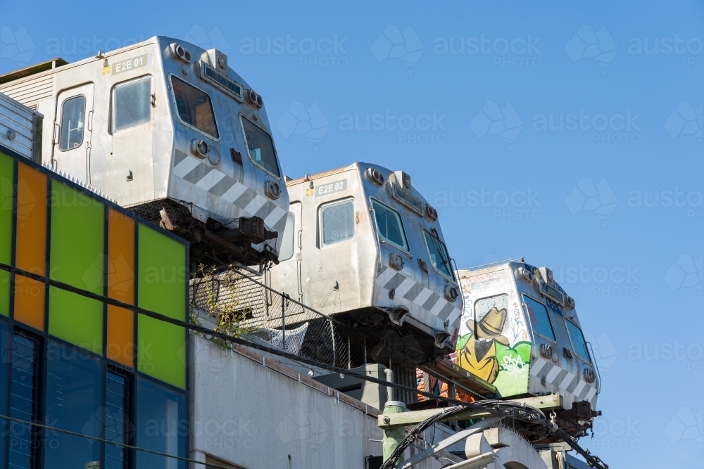 Image of Three train carriages sitting on the roof of a building ...