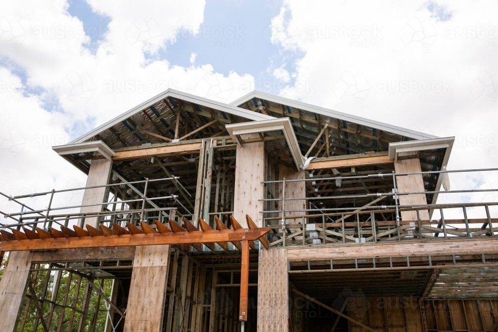 Image of timber framed two storey house under construction - Austockphoto