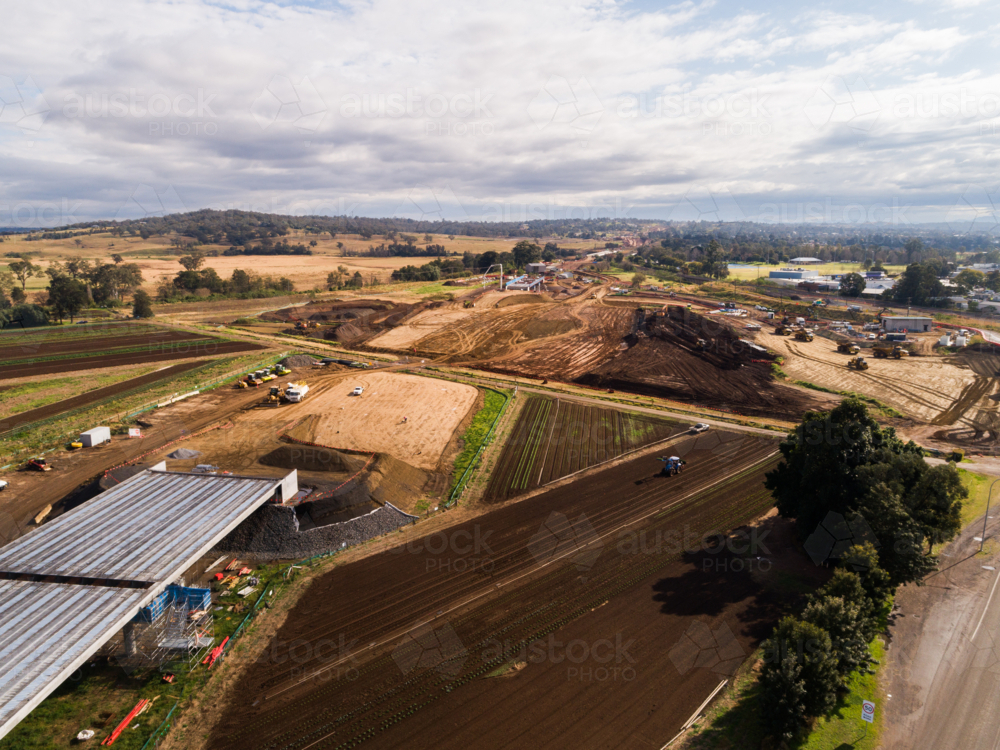 Image of tiny patch of agricultural farmland overshadowed by worksite ...