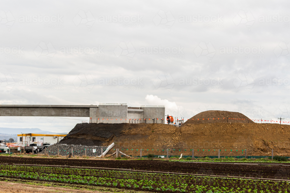 Image of tiny patch of agricultural farmland overshadowed by worksite ...