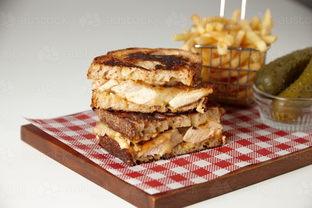 Image of Toasted chicken sandwich with chips and pickled cucumber ...