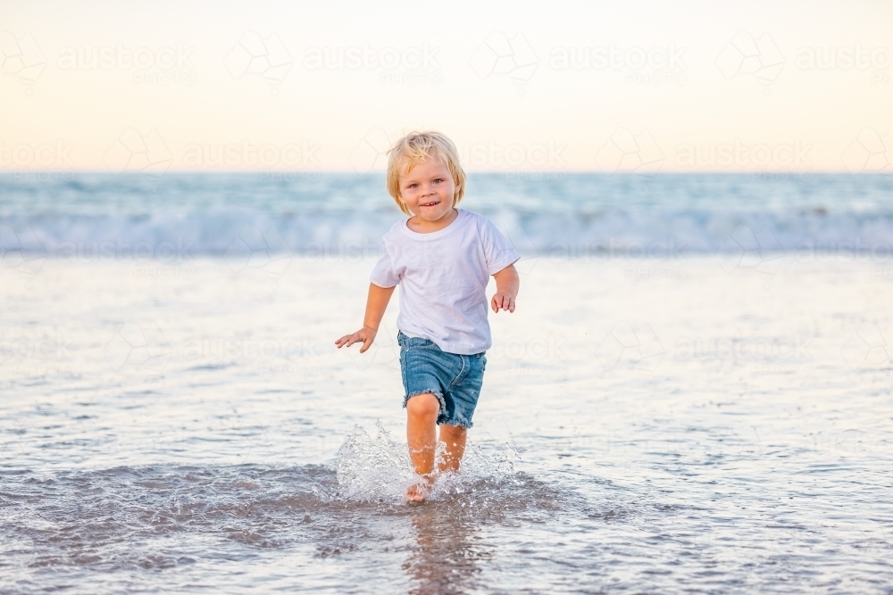 Image of Toddler boy playing in the waves on the beach on the Gold ...
