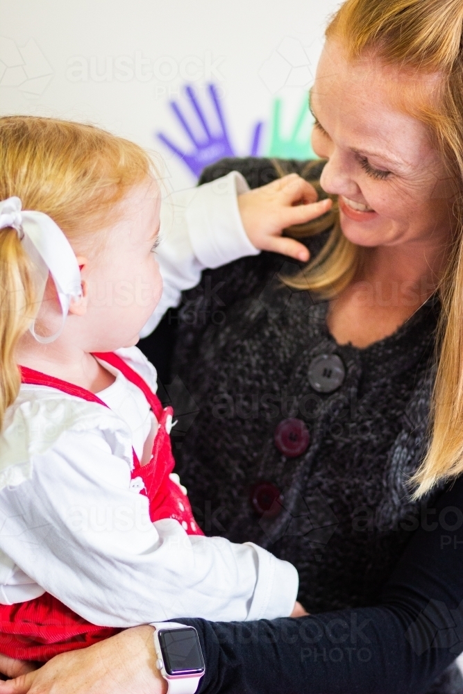 Image of Toddler child pointing to adults mouth - Austockphoto