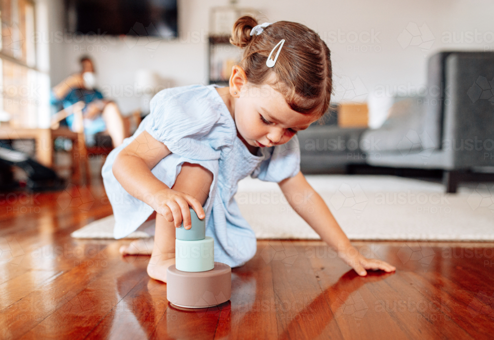 Image of Toddler girl building tower blocks on wooden floors ...
