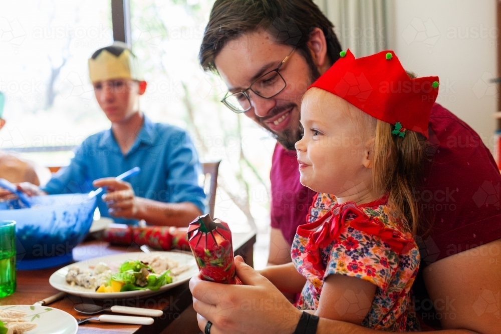 Image of Toddler girl with popped Christmas cracker at lunch with ...