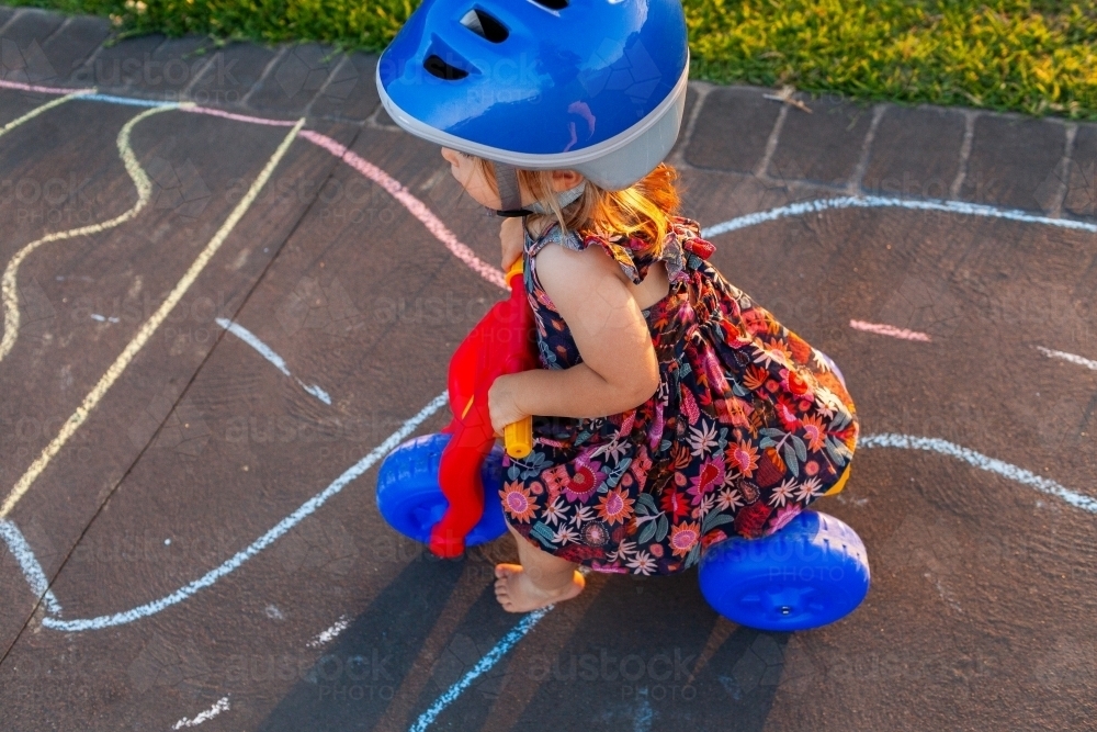 Image of Toddlers riding tricycle on driveway with chalk bike track ...