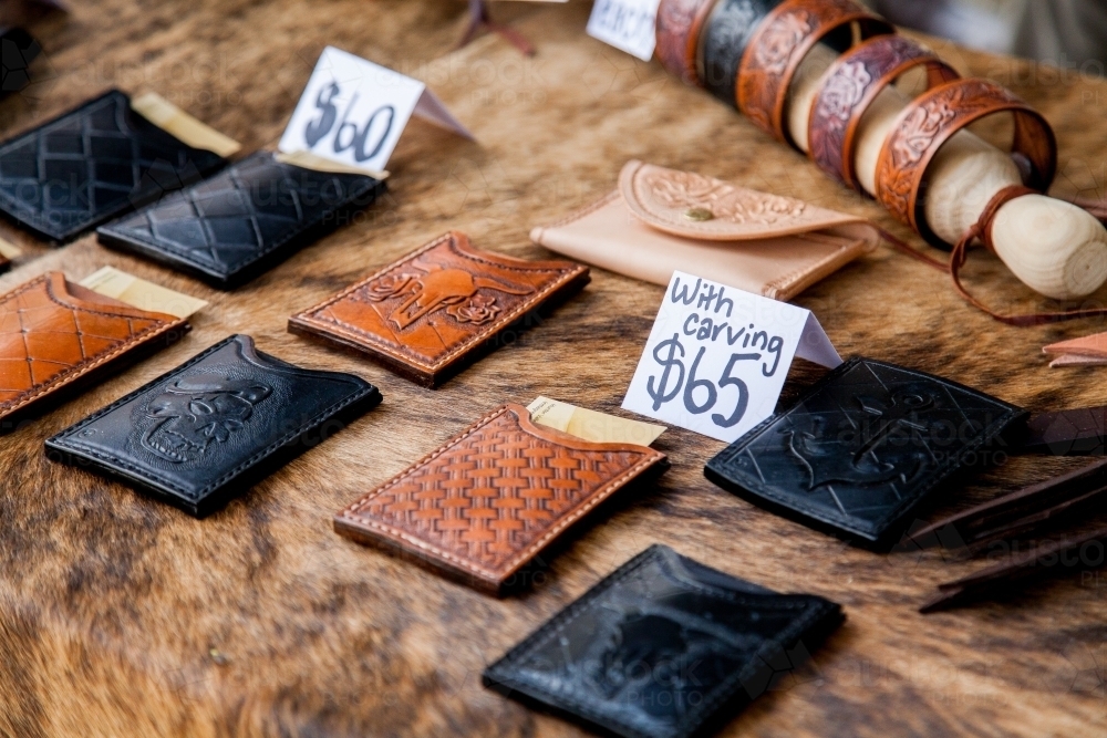 Image of Tooled leather wallets and cuffs on display at a market ...