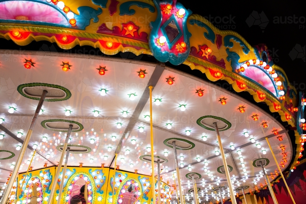Image of top of a carousel ride with lights on at night time - Austockphoto