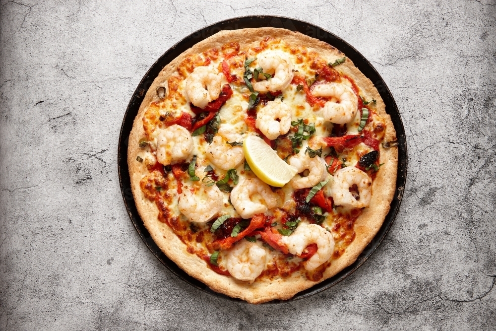 Image of top shot of garlic prawn pizza - Austockphoto