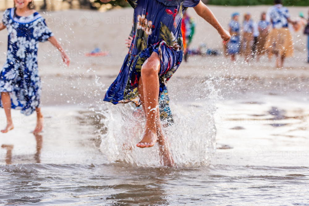 Image of Torres Strait Islander children running and splashing into ...