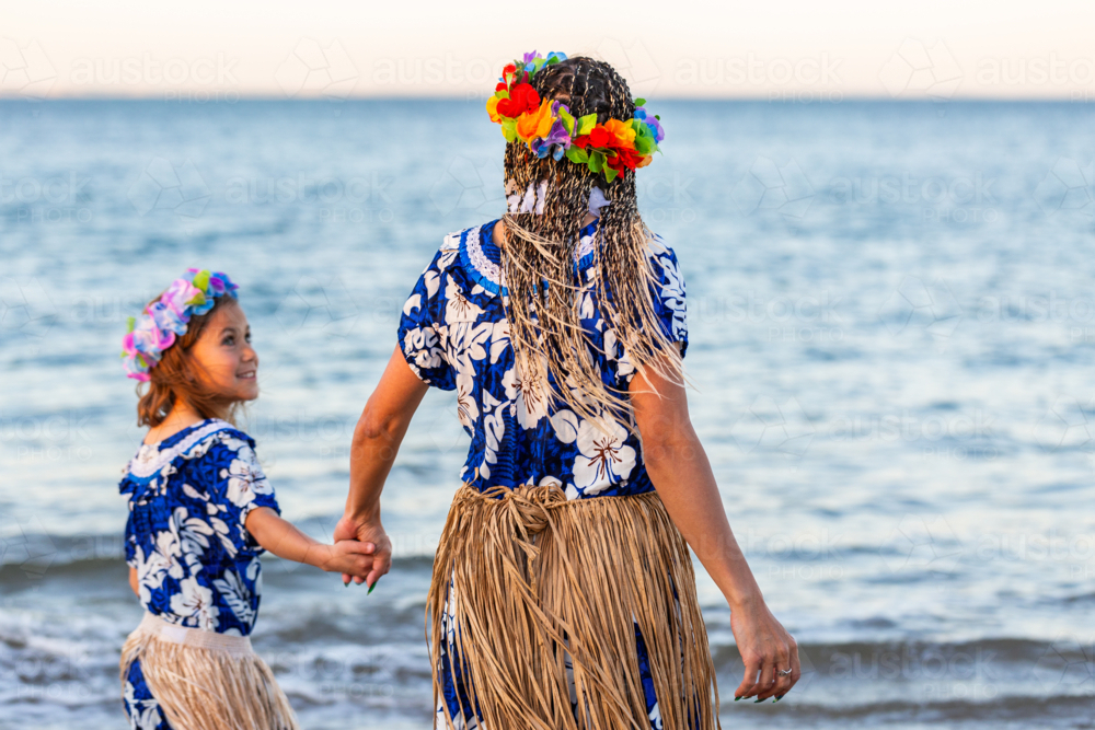 Image of Torres Strait Islander mother and young daughter in traditional floral costume and ...