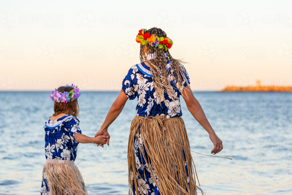 Image of Torres Strait Islander mother and young daughter in traditional floral costume and ...