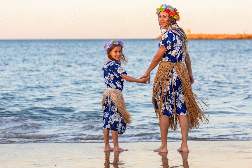 Image of Torres Strait Islander mother and young daughter in traditional floral costume and ...