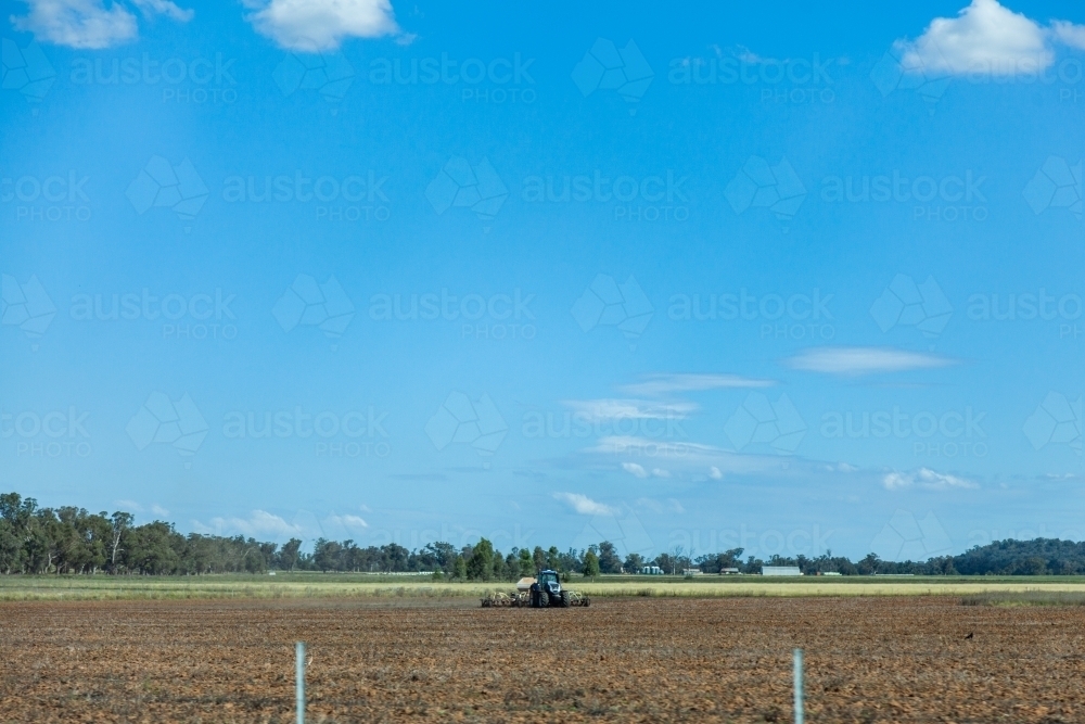 Image of Tractor in farm paddock beside the road in country with big ...