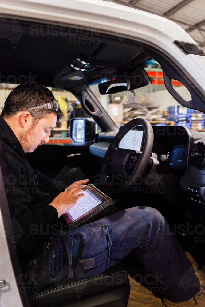 Image of tradesman mechanic with diagnostic device testing vehicle in ...