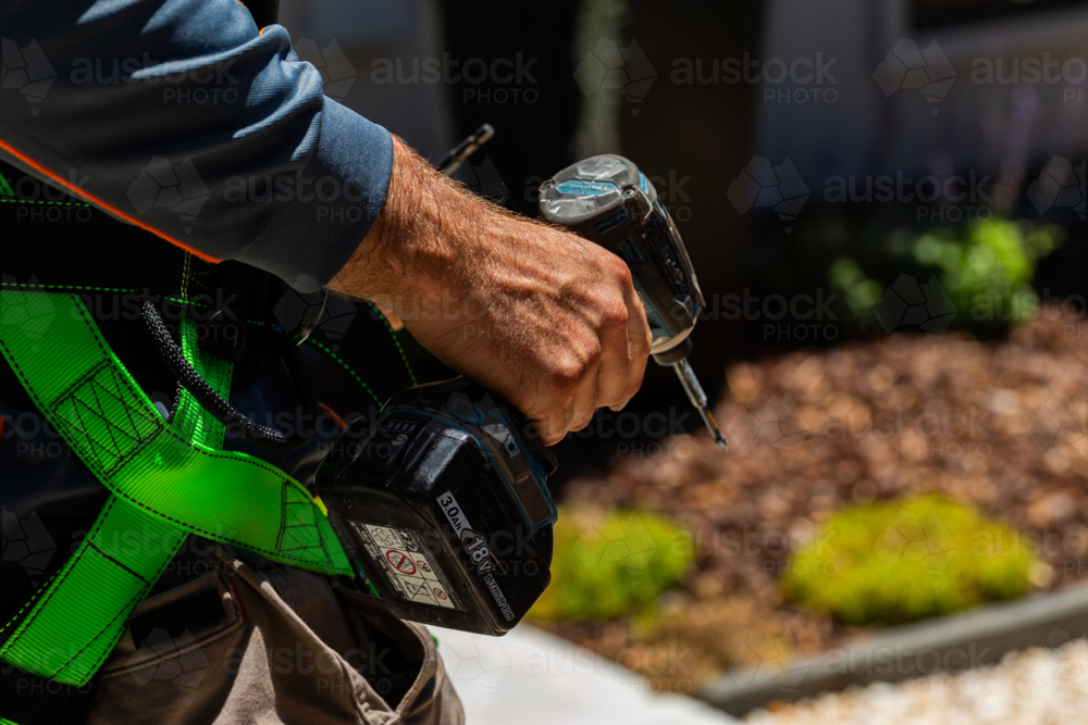 Image of Tradesman on worksite holding drill tool in hand - Austockphoto